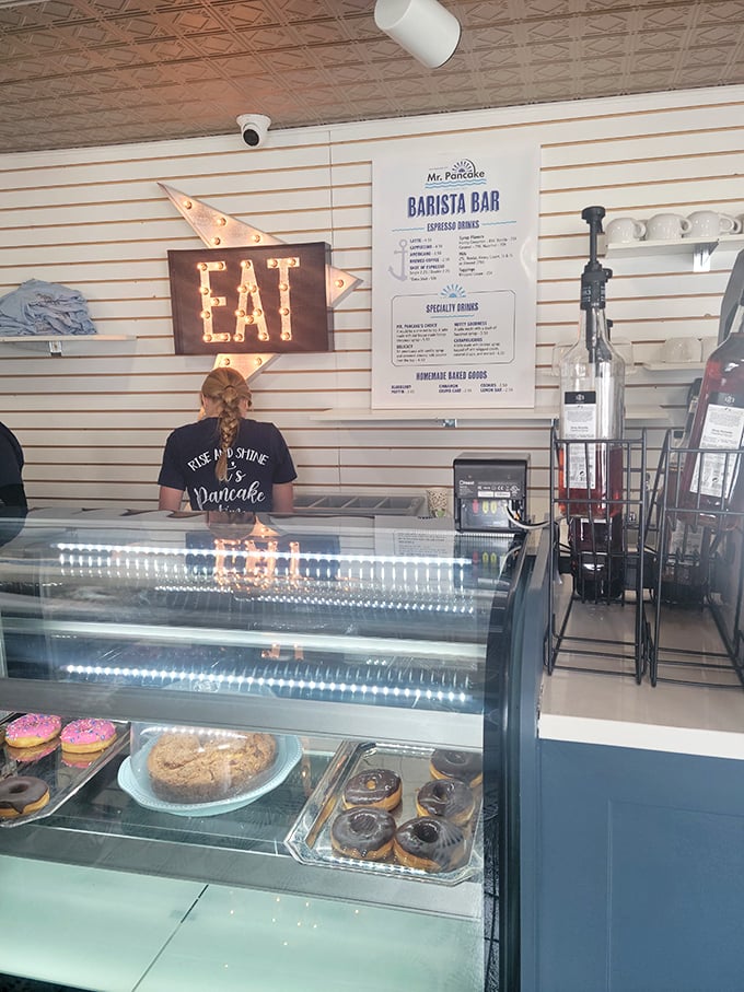 Behind this glass case lies temptation in pastry form, with a neon "EAT" sign that's less a suggestion and more a delicious command.