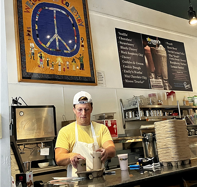Milkshake artistry in action. That focused expression is the look of someone who knows they're creating not just a drink, but a memory.