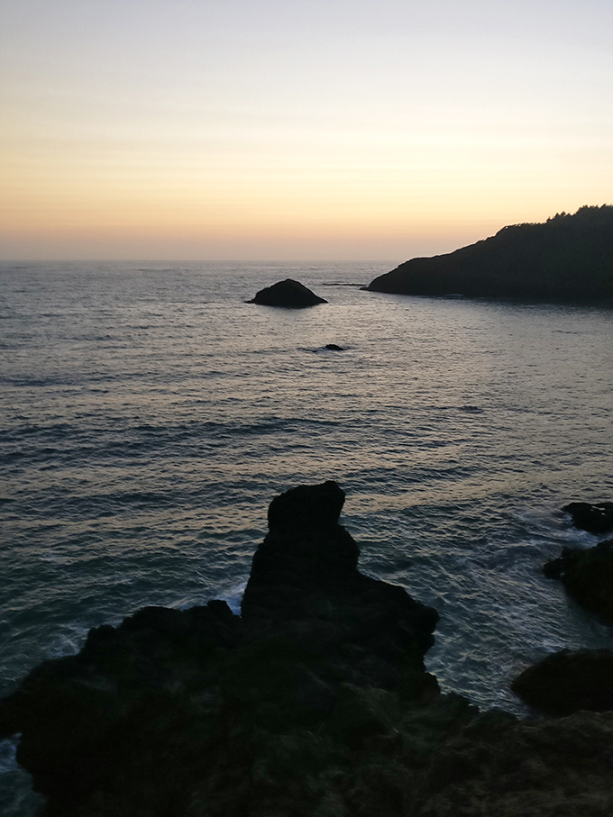 As the sun bids farewell, College Cove transforms into a silhouetted dreamscape of rocks, waves, and infinite possibility.