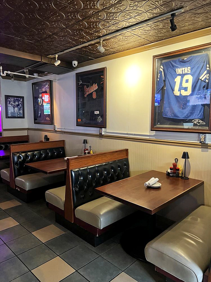Cozy booth seating with Ravens memorabilia overhead &ndash; where sports passion meets serious dining in perfect harmony.