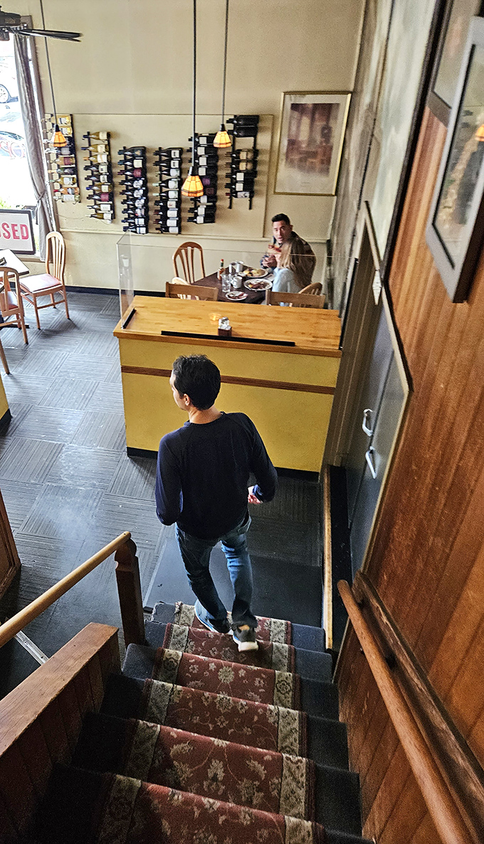 The staircase view reveals multiple levels of dining, where conversations and coffee create the perfect soundtrack to your morning feast.