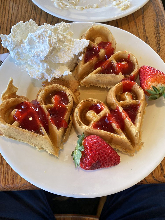 Heart-shaped waffles topped with strawberries prove that breakfast foods can wear romantic formalwear while still tasting like home.