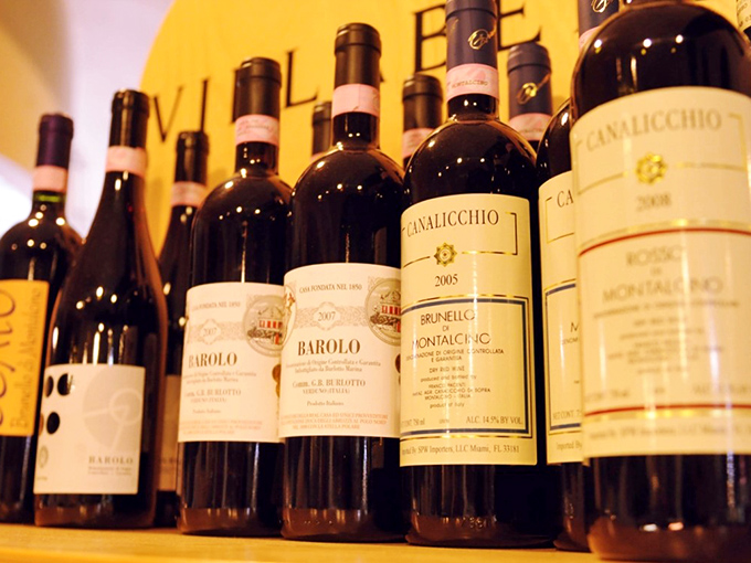 Wine bottles lined up like well-dressed guests at a party. Each one has a story to tell, and by the end of dinner, you'll know them all intimately.