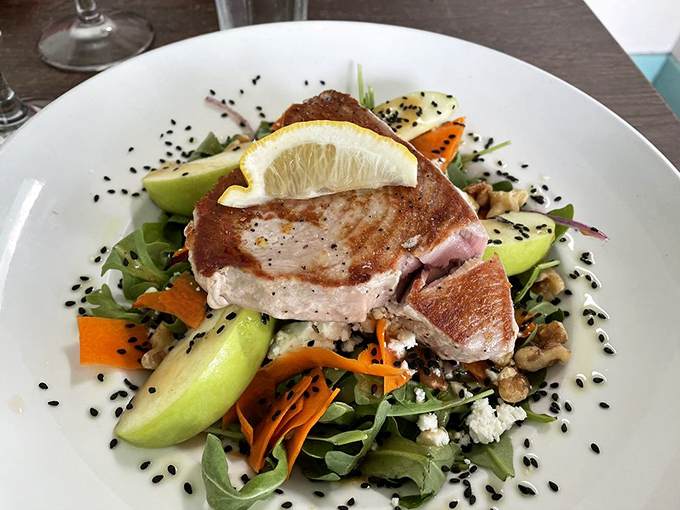 Perfectly seared tuna perched atop a colorful salad like it's surveying its delicious kingdom. The sesame seeds add both texture and visual drama.