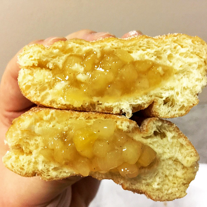 Cut open an apple-filled donut and witness the miracle &ndash; tender chunks of cinnamon-spiced fruit nestled in a pocket of fried perfection.