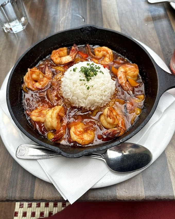 BBQ shrimp served in a cast iron skillet&mdash;because when food is this good, it deserves dramatic presentation and a perfect rice island in a sea of savory sauce.
