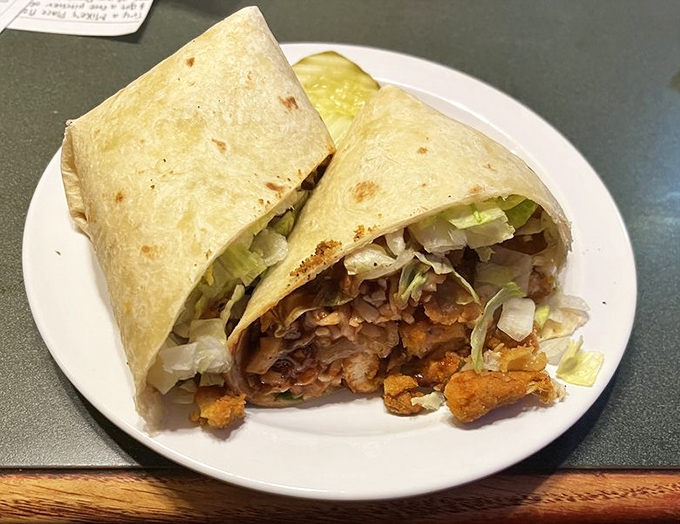 Wrapped perfection: crispy chicken, fresh lettuce, and whatever magic they've tucked inside that tortilla. Portable deliciousness at its finest.