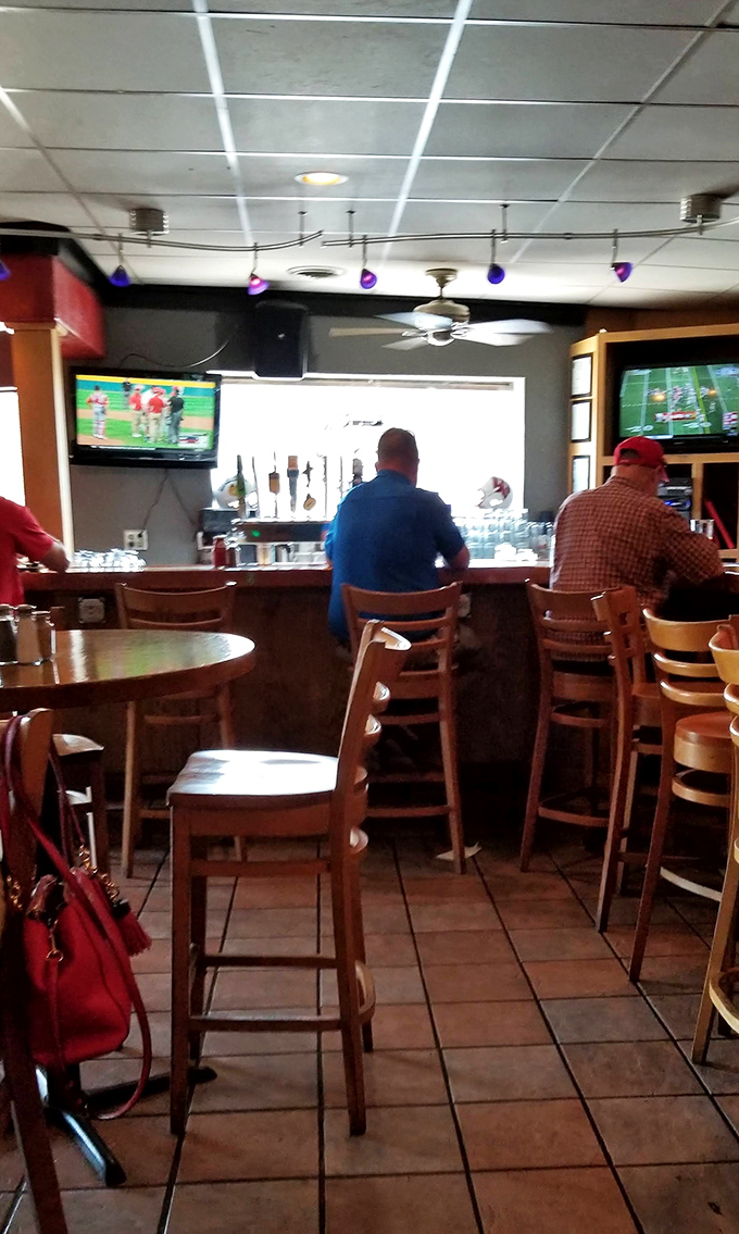 The best seats in the house offer prime viewing of both the game and the bartender's pouring technique. Strategic positioning at its finest.