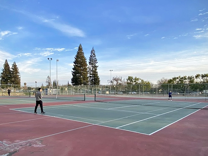 Tennis courts bathed in golden hour light await your serve, where "love" means both the score and how you feel about not fighting for court time.