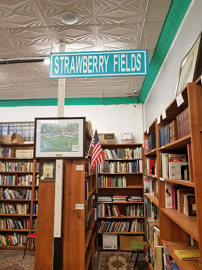 Under the "Strawberry Fields" sign, books wait patiently for new readers. This literary corner offers first editions, forgotten classics, and that new-old book smell.
