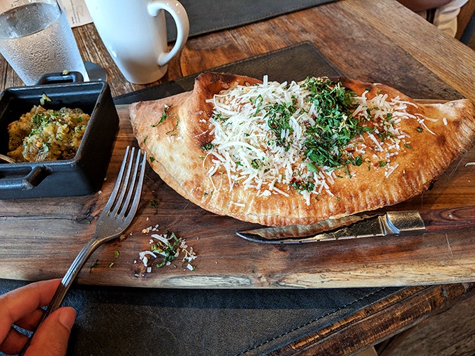 A calzone that makes pizza feel underdressed. Golden-brown crust cradling molten cheese and savory fillings &ndash; the sleeping bag of comfort food.