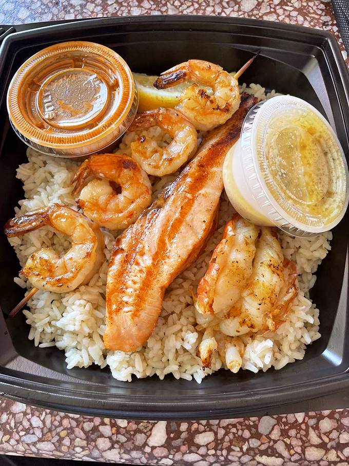 The charbroil sampler&mdash;where indecision becomes a virtue. Shrimp and fish living harmoniously on a bed of rice, with sauce cups standing by for optional enhancement.
