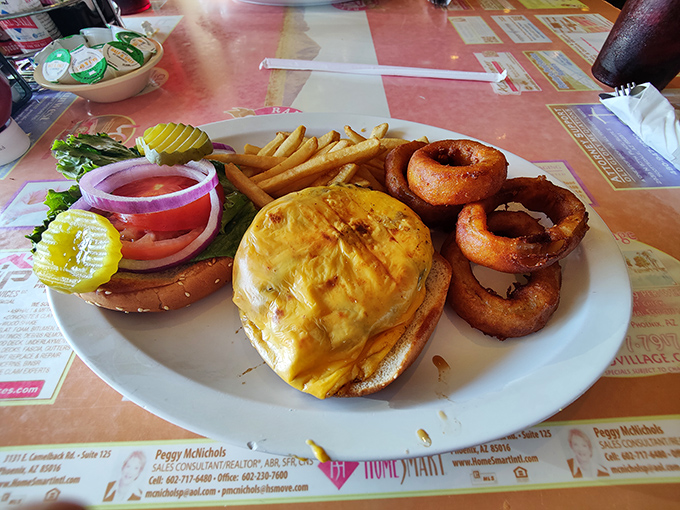 A burger that requires jaw exercises beforehand, accompanied by onion rings that achieve the perfect crunch-to-softness ratio every cardiologist fears.