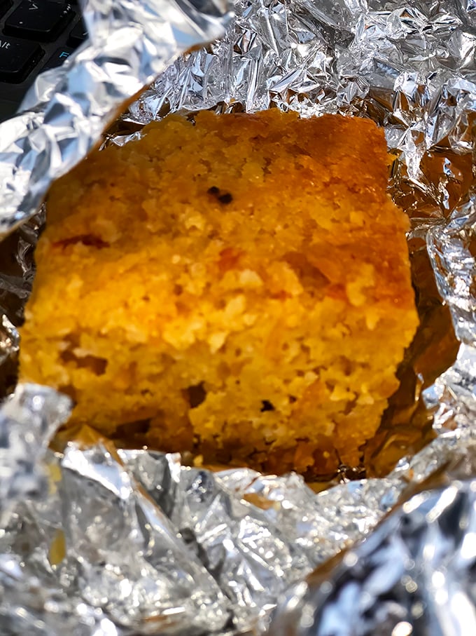 Cornbread wrapped in foil like the precious gift it is&mdash;golden, crumbly, and ready to complete your barbecue experience with buttery perfection.