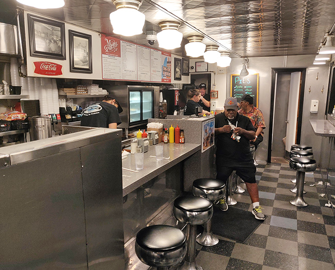 The narrow counter where strangers become temporary friends, united by the shared experience of watching their food prepared before their eyes.