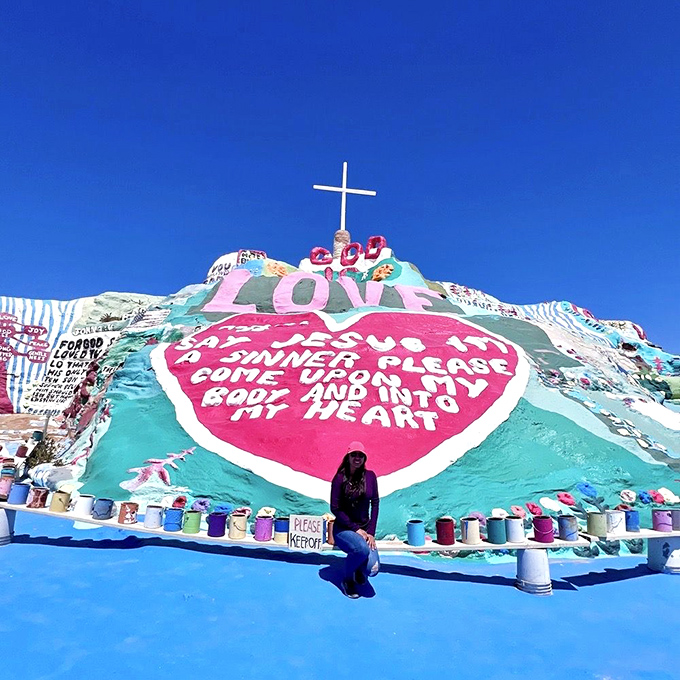 Against the massive red heart, visitors appear doll-sized, offering perfect perspective on just how monumental this hand-built attraction truly is.