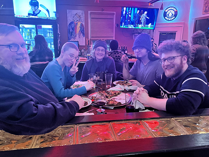 Great food creates great moments. These diners aren't just eating pizza—they're building memories around a table where phones take a backseat to conversation.