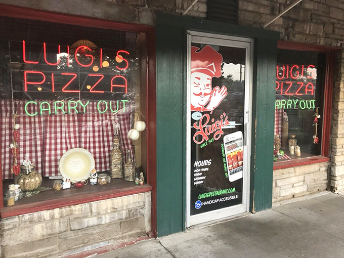 The neon glow of Luigi's windows promises pizza paradise within, a beacon of hope for the hungry souls of Akron.