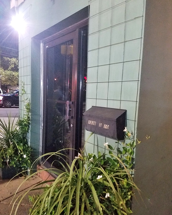 The unassuming entrance, flanked by greenery, doesn't hint at the culinary adventures waiting inside this South Philly gem.