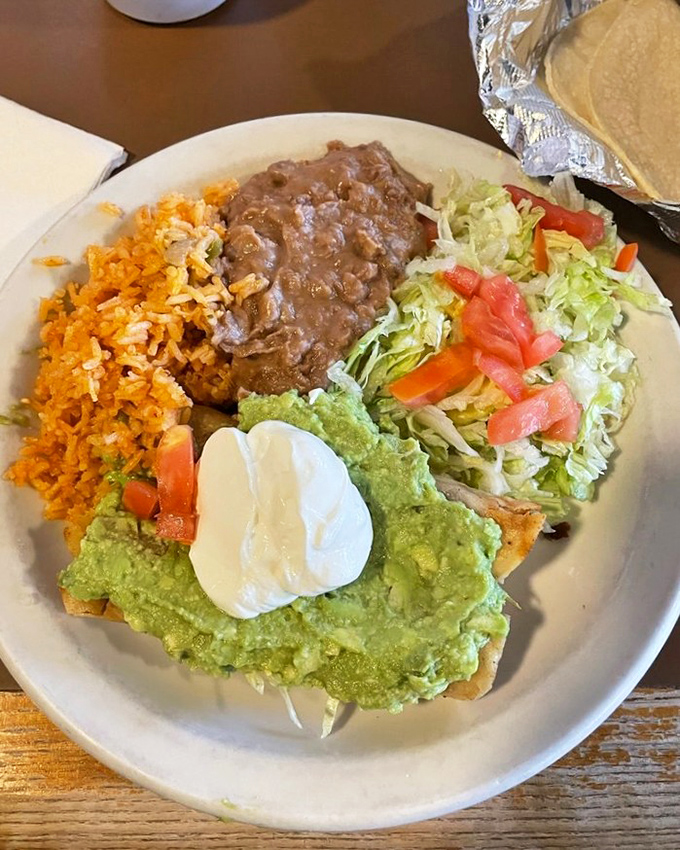 Flautas arranged like a delicious sunburst, surrounded by guacamole, sour cream, and pico de gallo &ndash; proof that the best things in life come with multiple dipping options.