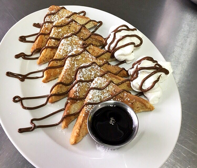 French toast triangles dressed for success. Powdered sugar, chocolate drizzle, and a side of syrup make breakfast feel like dessert.