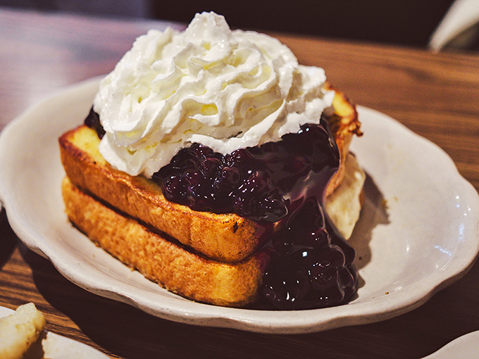 French toast that flirts with dessert territory &ndash; berry compote cascading down golden bread with a cloud of whipped cream playing matchmaker.
