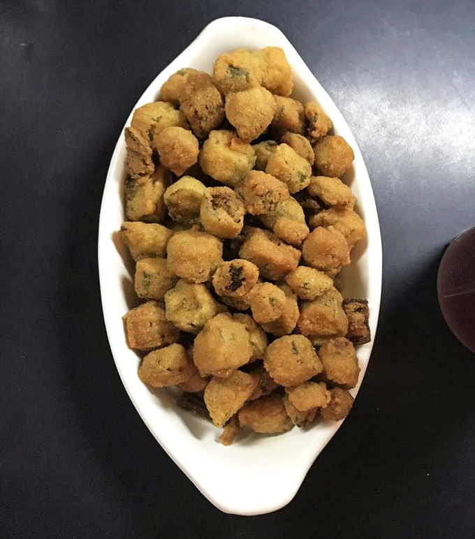 Fried okra so perfectly golden and crisp, it converts vegetable skeptics into true believers. The South's greatest ambassador in bite-sized form.