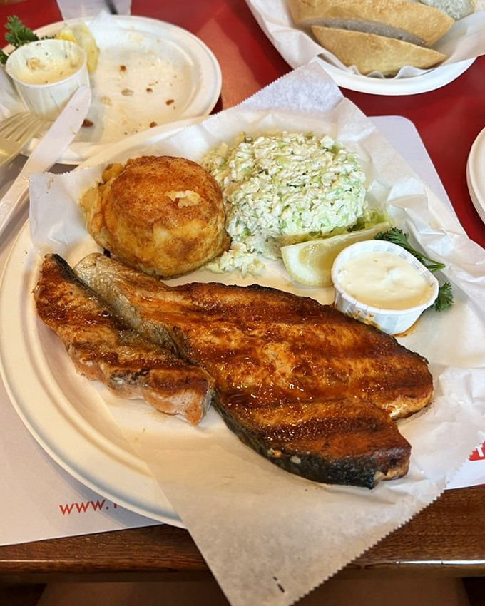 A plate that tells California's story: perfectly grilled salmon, a golden crab cake, and coleslaw that tastes like summer by the shore.