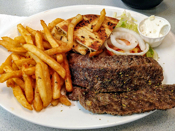 A plate that would make Zeus himself nod in approval&mdash;perfectly seasoned steak, golden fries, and all the fixings of a proper Greek-American feast.