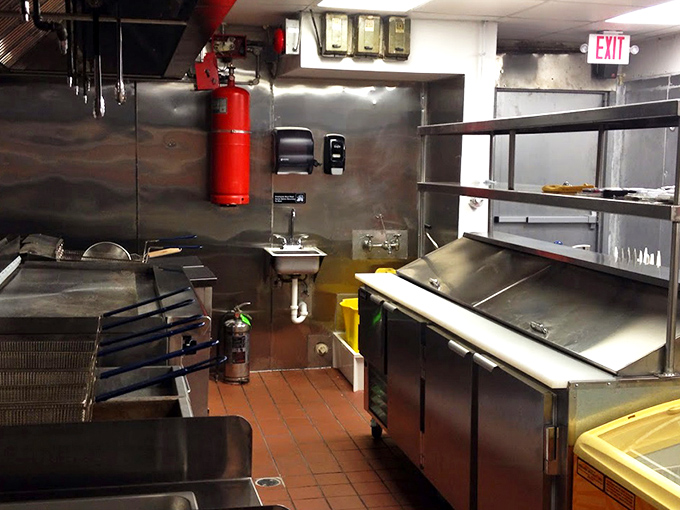 Behind the scenes in the kitchen, gleaming stainless steel equipment stands ready for the daily ritual of creating perfectly fried chicken.