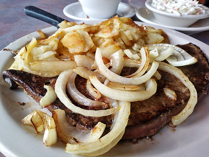 A steak topped with saut&eacute;ed onions and home fries &ndash; proof that diners understand the art of simple, satisfying food better than anywhere else.