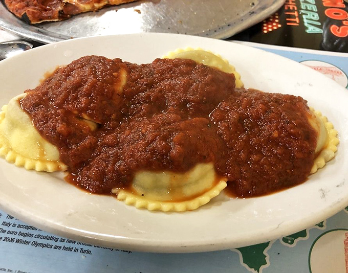 Ravioli swimming in a sea of rich tomato sauce&mdash;pasta pillows that have comforted more souls than any therapist's couch ever could.