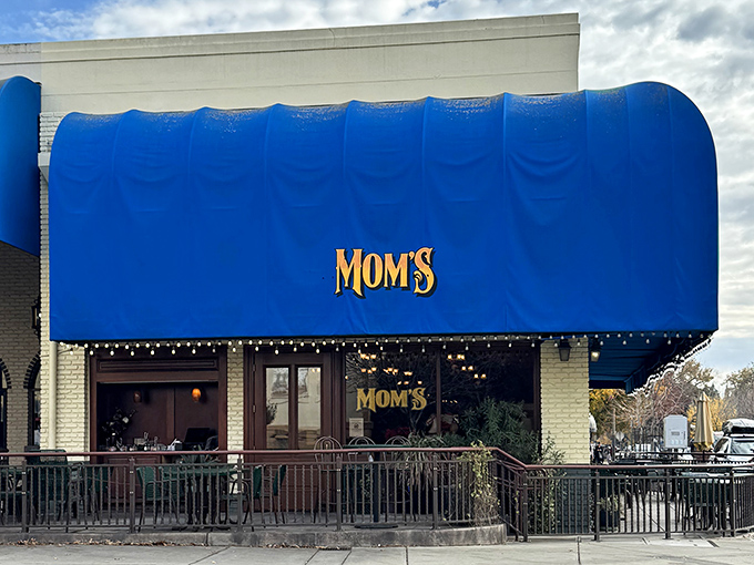 Mom's Restaurant's bold blue awning signals the kind of unpretentious dining where comfort food comes with a side of genuine conversation, not inflated coastal prices.