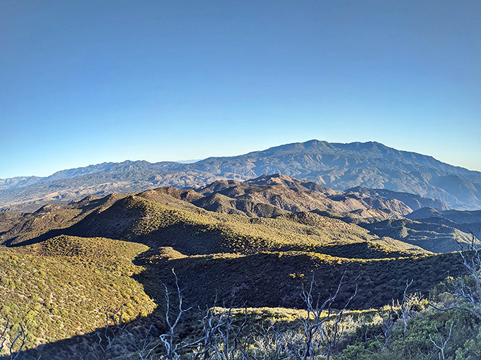Mountain layers unfold like nature's tiramisu &ndash; each ridge a different shade of purple and gold in the late afternoon light.