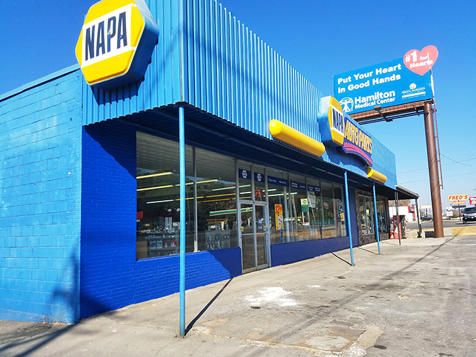The brilliant blue NAPA Auto Parts store stands out like a peacock in a chicken coop—automotive salvation for DIYers and professionals alike.