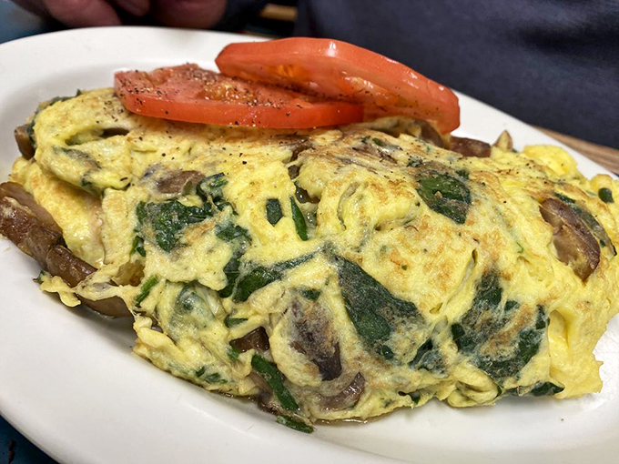 This isn't just an omelet&mdash;it's a fluffy yellow canvas painted with mushrooms and spinach, a breakfast masterpiece served with sliced tomato garnish.