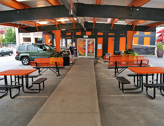 Even the outdoor seating area maintains the signature orange and black theme. A perfect spot for people-watching between bites.