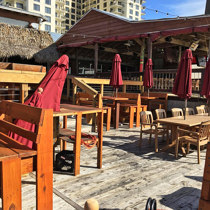 The outdoor dining area&mdash;where the Gulf breeze serves as both air conditioning and appetite enhancer. Those red umbrellas? Just showing off.