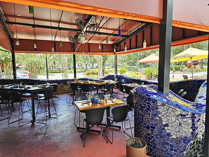 The outdoor dining area offers a breezy Florida experience with mosaic dividers that look like they were stolen from Gaud&iacute;'s sketchbook.