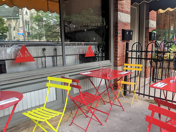 Colorful bistro tables create a confetti-like splash against the sidewalk. These cheerful seats have "lingering over coffee" written all over them.
