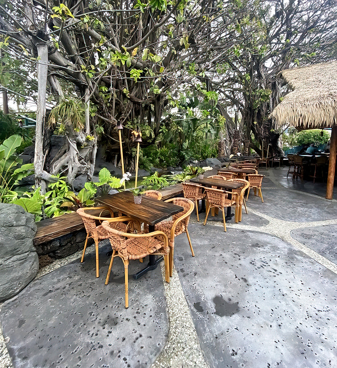 Wicker chairs and wooden tables nestled among lush greenery create the perfect spot for intimate conversations and island-inspired meals.