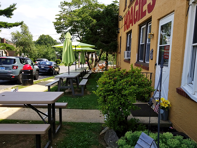 Outdoor seating under green umbrellas offers a peaceful sandwich sanctuary. Nature and nurture combine for the perfect dining experience.