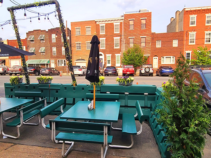 The outdoor picnic tables say "stay awhile" with their cheerful turquoise color and string lights promising good times as daylight fades.