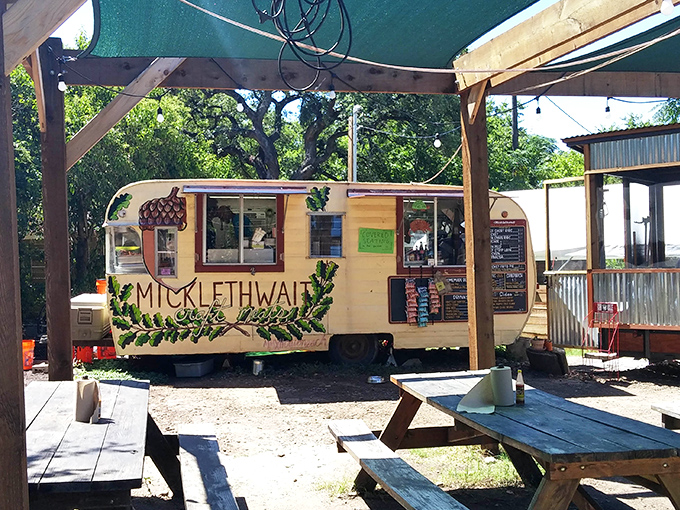 Outdoor picnic tables under Texas shade—because sometimes great barbecue deserves fresh air and the company of oak trees.