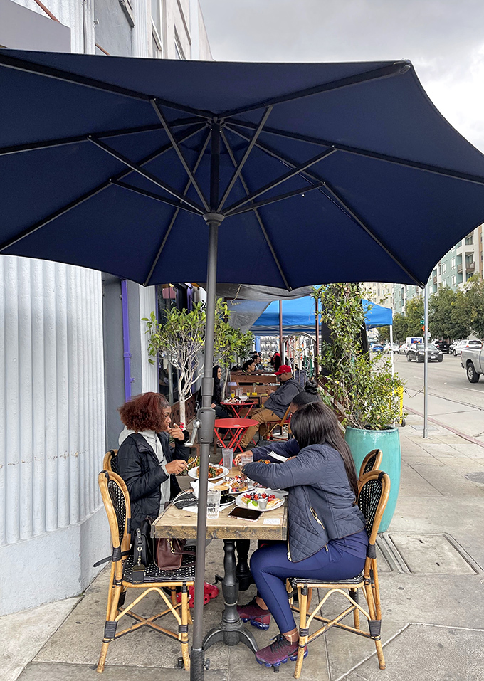 Sidewalk dining under blue umbrellas &ndash; because waffles taste even better with a side of people-watching and fresh LA air.
