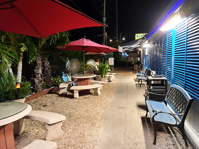 The outdoor waiting area offers a taste of Keys tranquility, with palm trees and red umbrellas creating a perfect pre-dinner atmosphere.