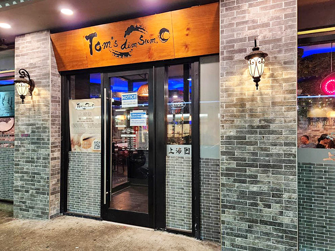 The evening entrance to Tom's beckons like a portal to Shanghai, the warm glow from within promising comfort and culinary adventure.
