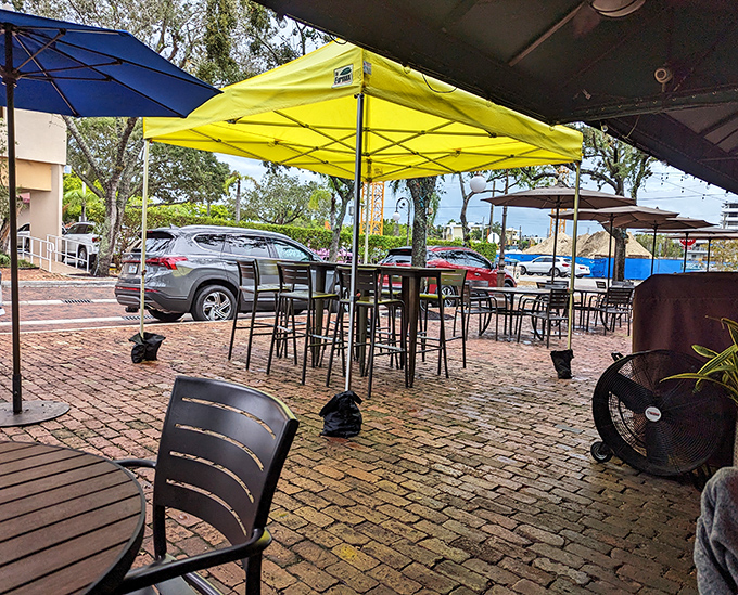 Brick pavers and colorful umbrellas create an outdoor oasis where Florida's weather becomes part of the ambiance rather than something to escape..