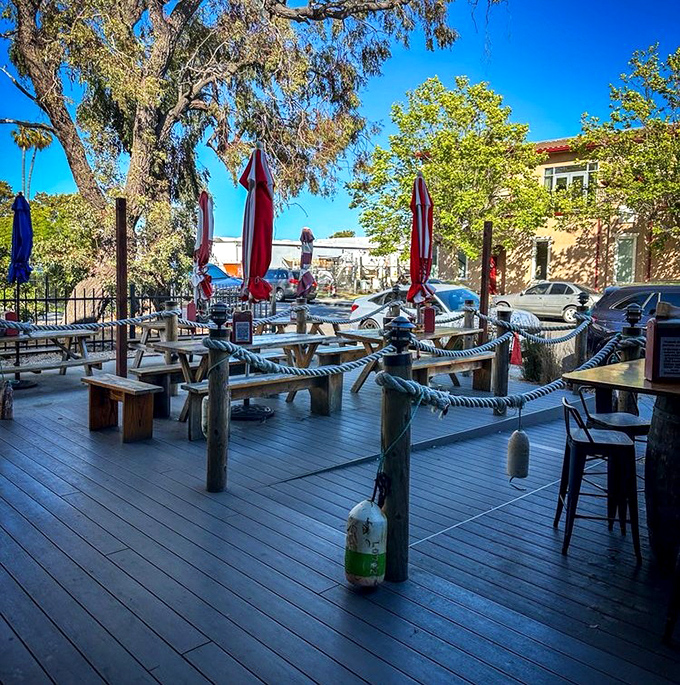 The outdoor deck with its nautical rope railings and wooden posts channels pure New England vibes. Those red umbrellas aren't just for shade—they're beacons for seafood lovers.