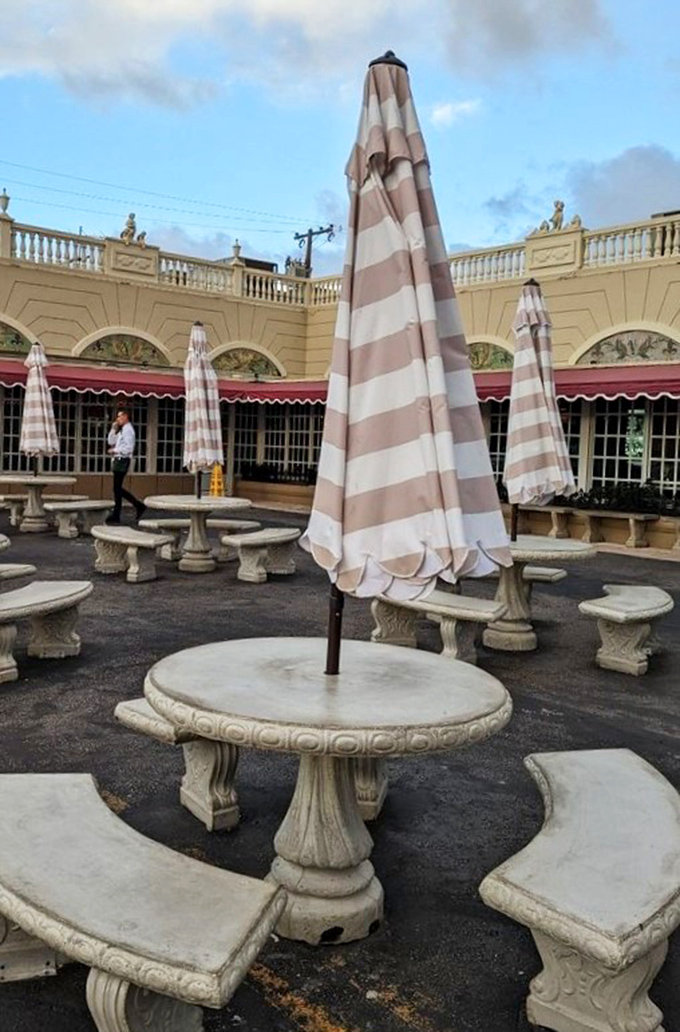 Stone tables await beneath striped umbrellas, offering al fresco dining with a side of people-watching and Miami sunshine.